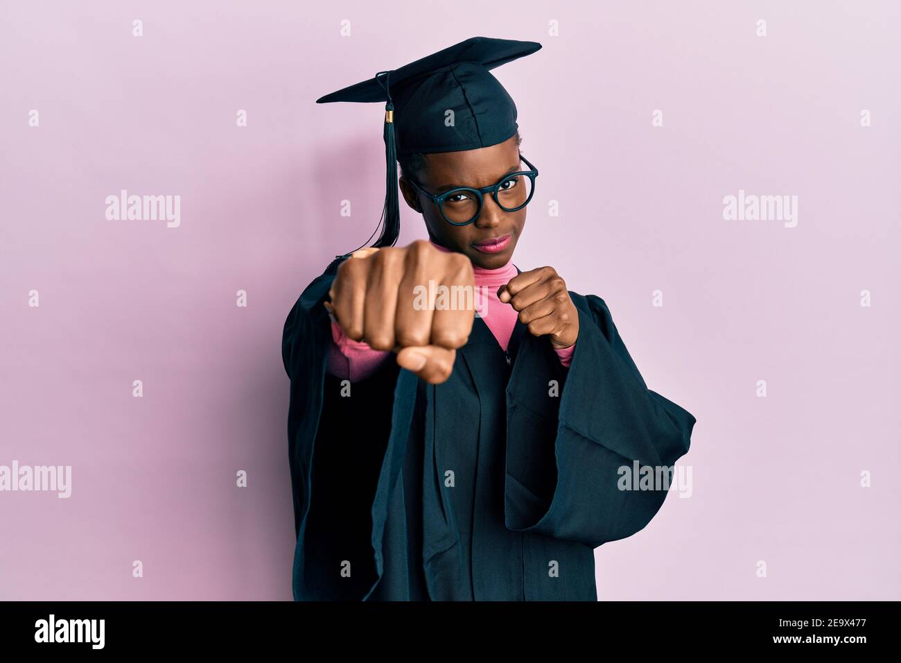 Young african american girl wearing graduation cap and ceremony robe ...