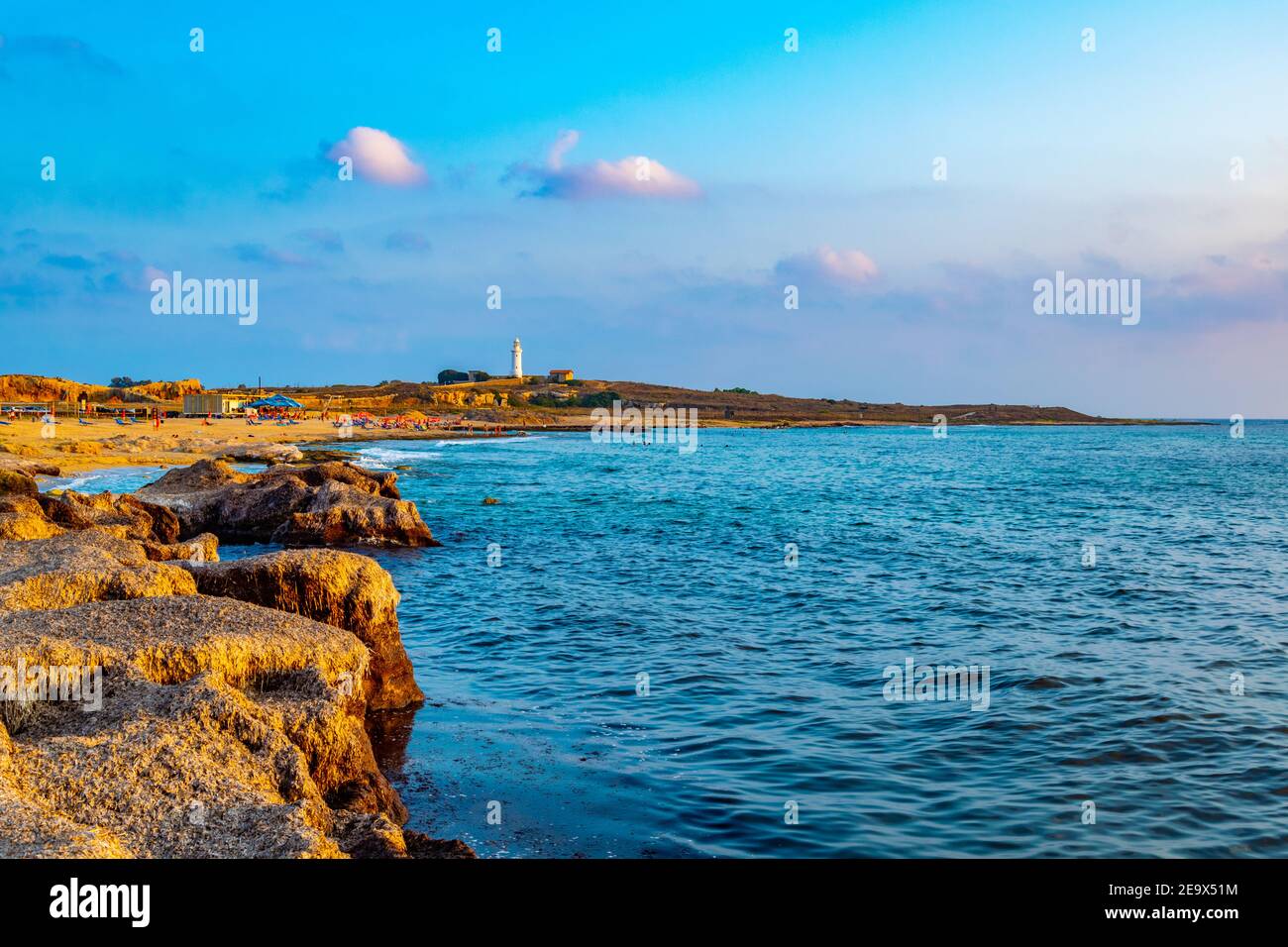 Sunset on a beach in Paphos with white lighthouse on background, Cyprus ...