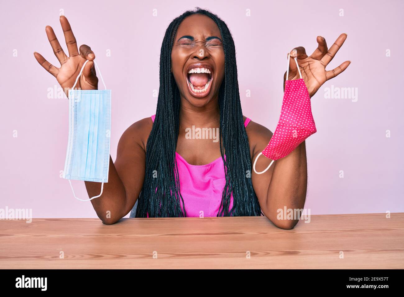 African american woman with braids holding two different safety masks ...