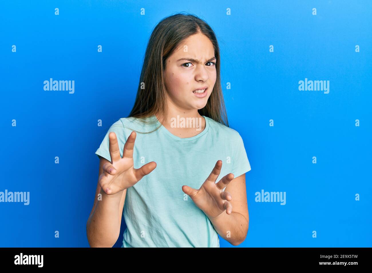 Beautiful brunette little girl wearing casual white t shirt disgusted ...