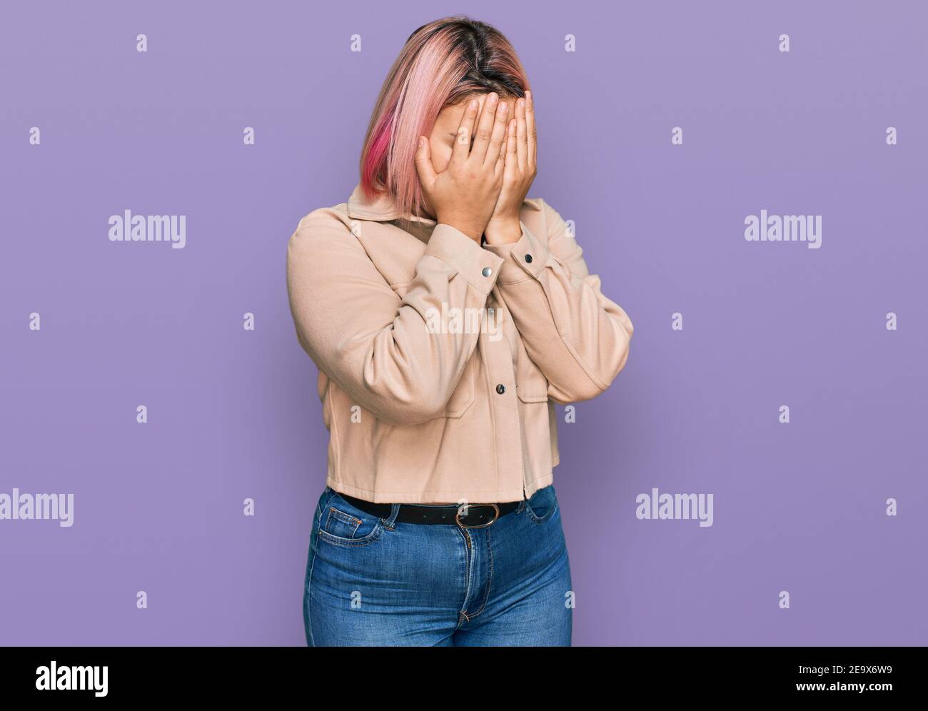 Hispanic woman with pink hair wearing casual clothes with sad ...