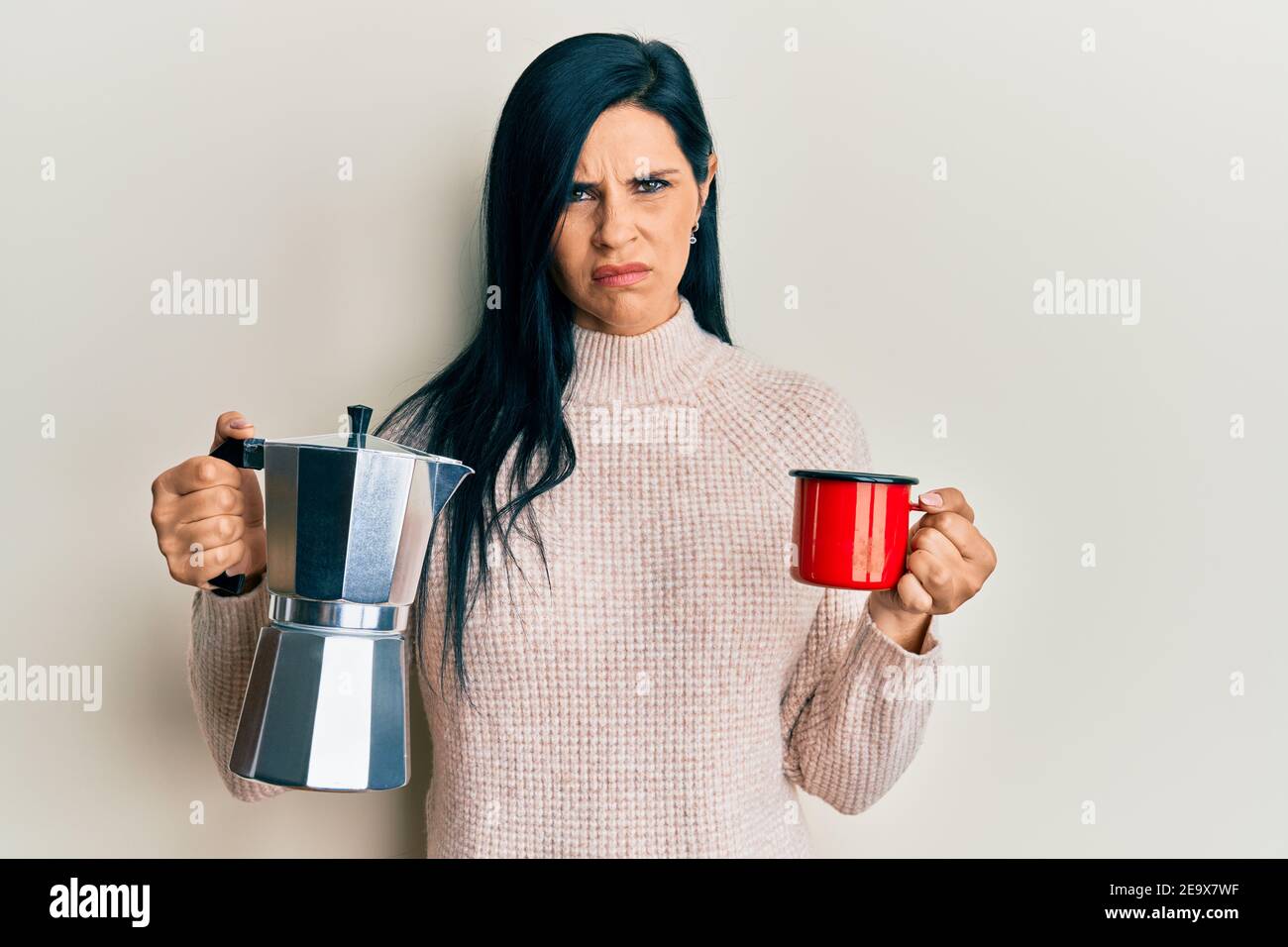 Young caucasian woman drinking italian coffee skeptic and nervous ...