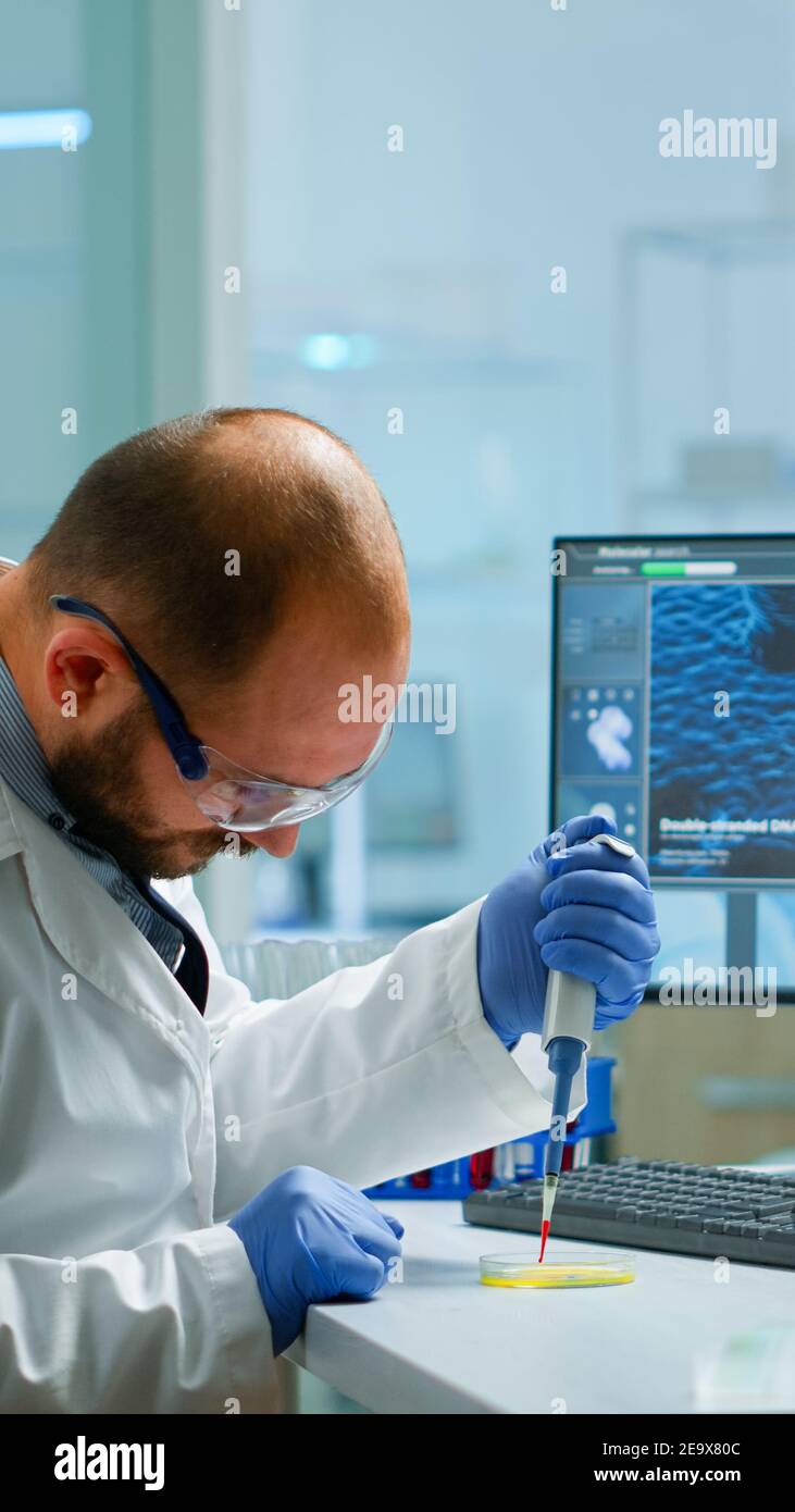 Man scientist using micropipette for filling test tubes in modern ...