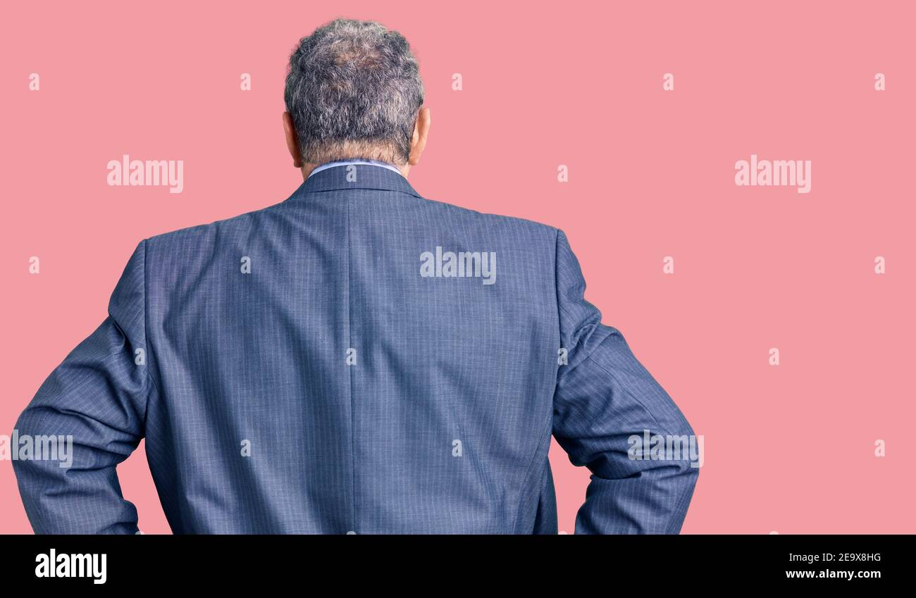 Senior grey-haired man wearing business jacket standing backwards ...