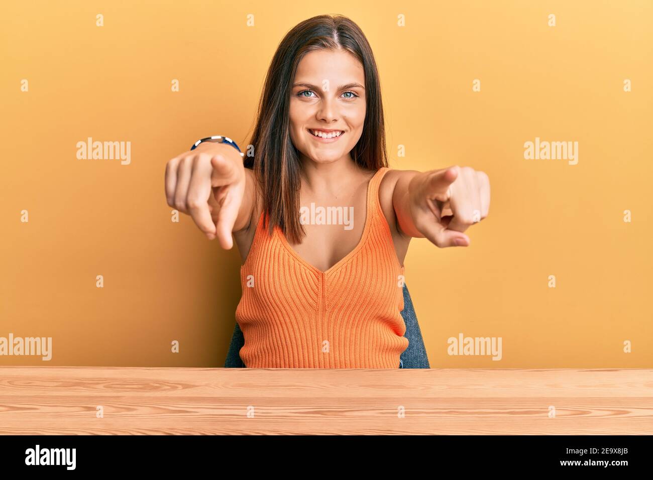 Young caucasian woman wearing casual clothes sitting on the table ...