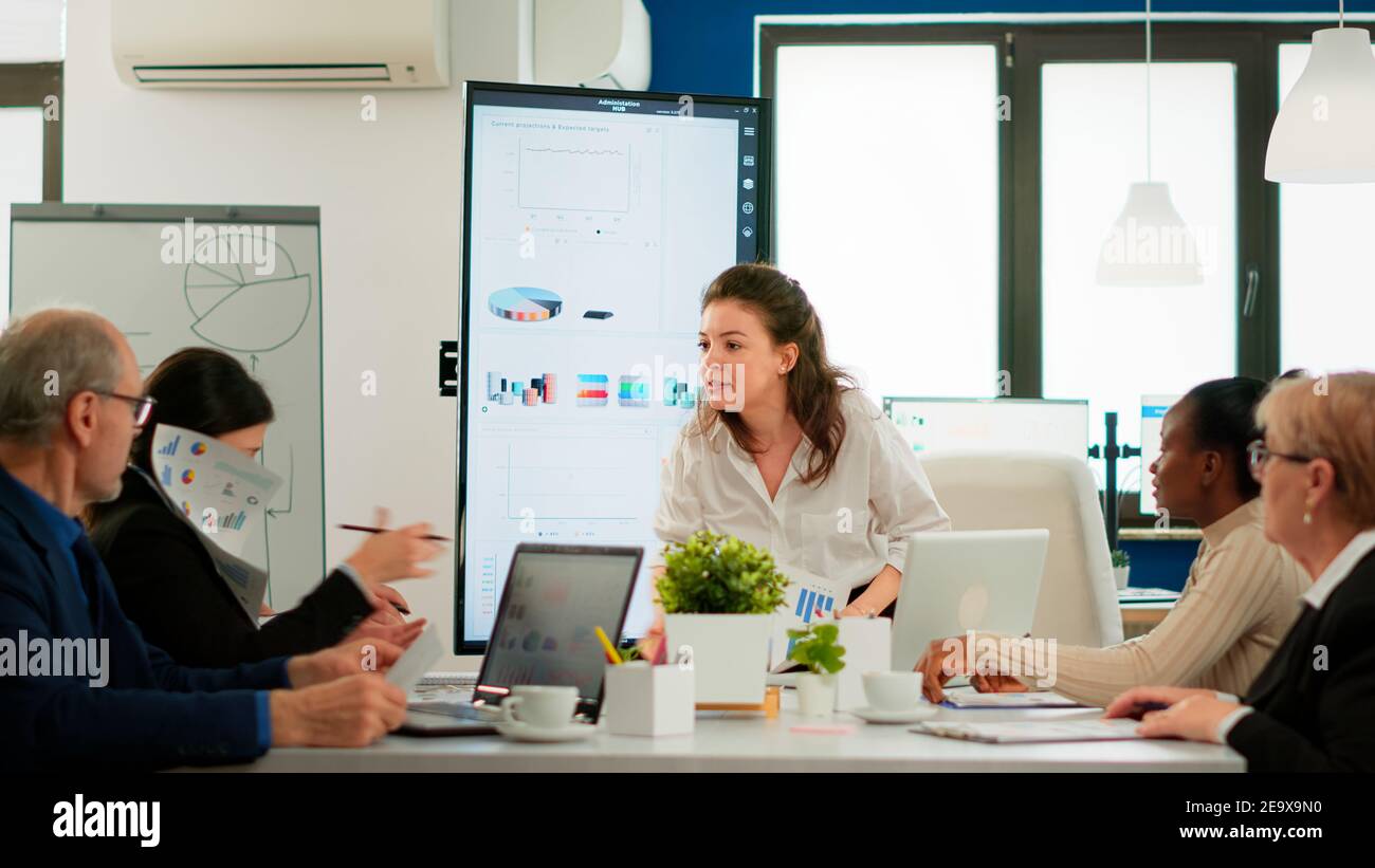 Furious woman manager arguing employees for bad work result, sitting ...