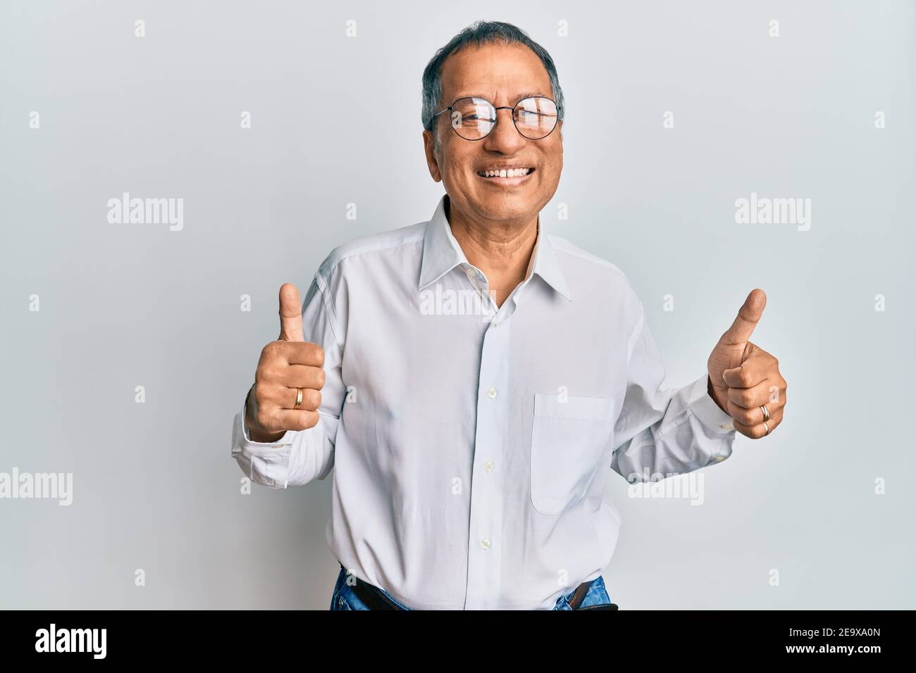 Middle Age Indian Man Wearing Casual Clothes And Glasses Success Sign