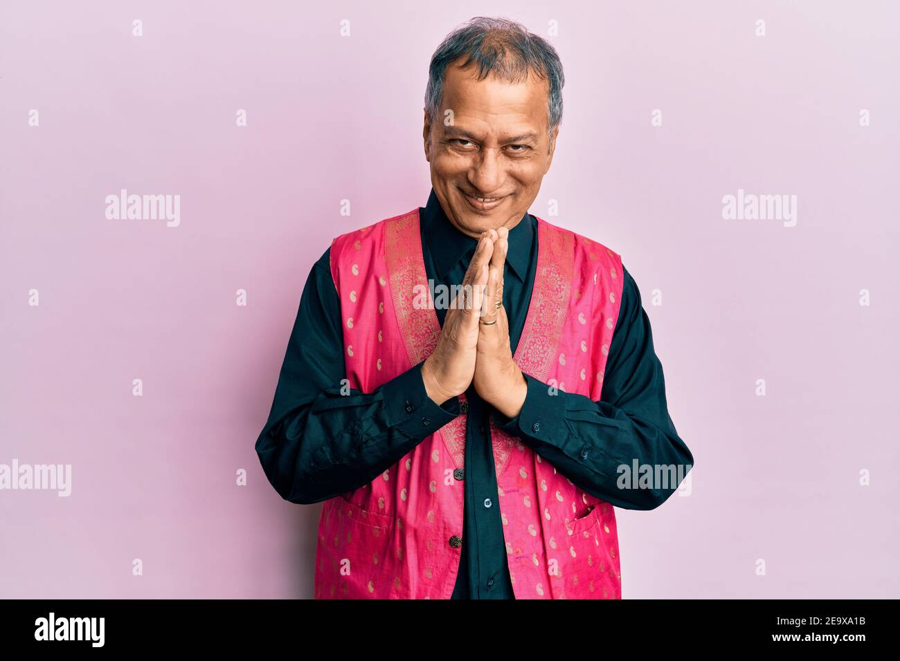 Middle age indian man wearing traditional indian clothes praying with ...