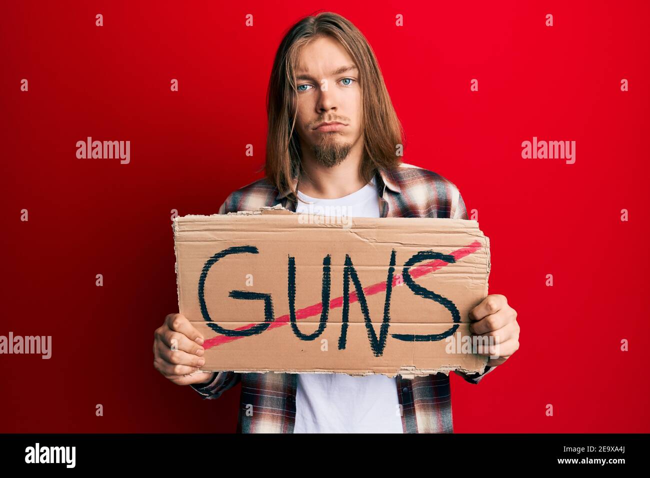 Handsome caucasian man with long hair holding no guns warning banner ...