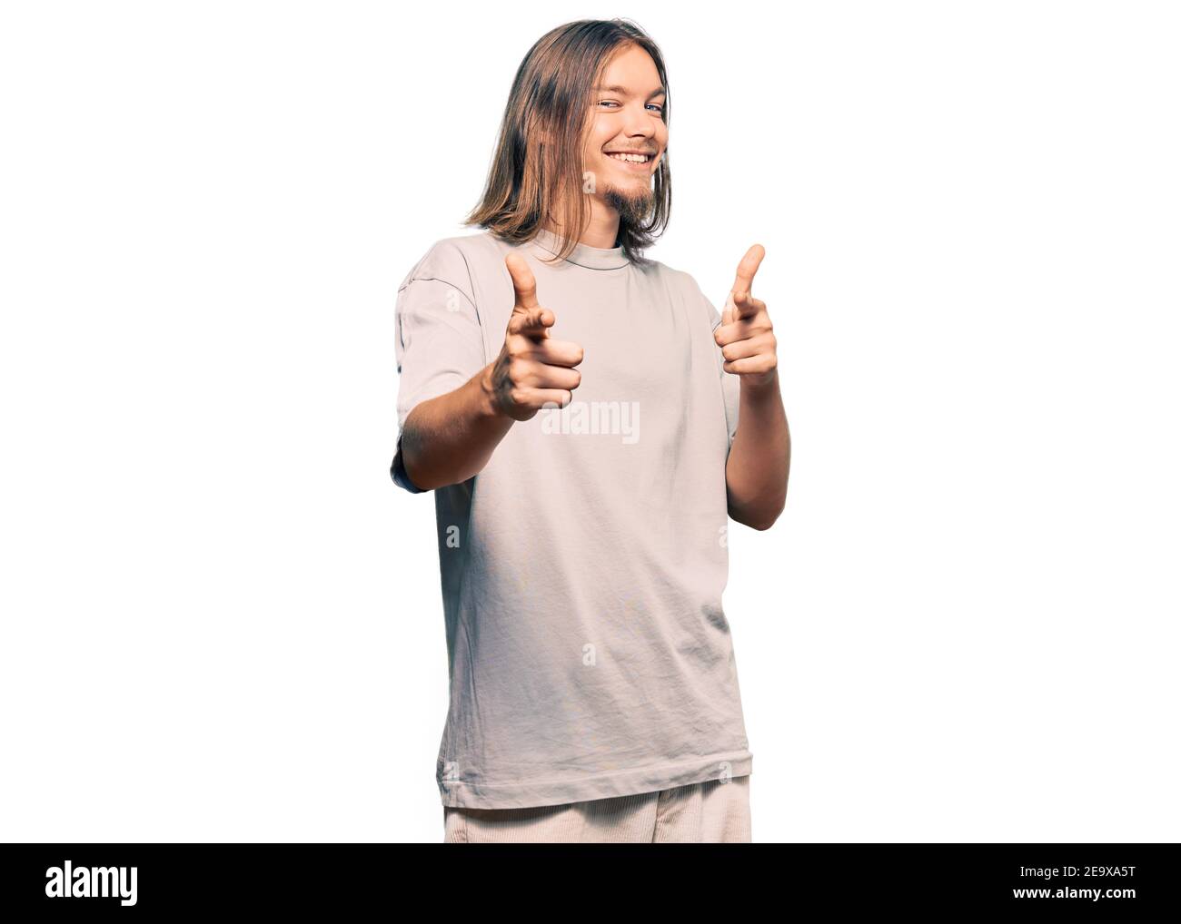 Handsome caucasian man with long hair wearing casual clothes pointing ...