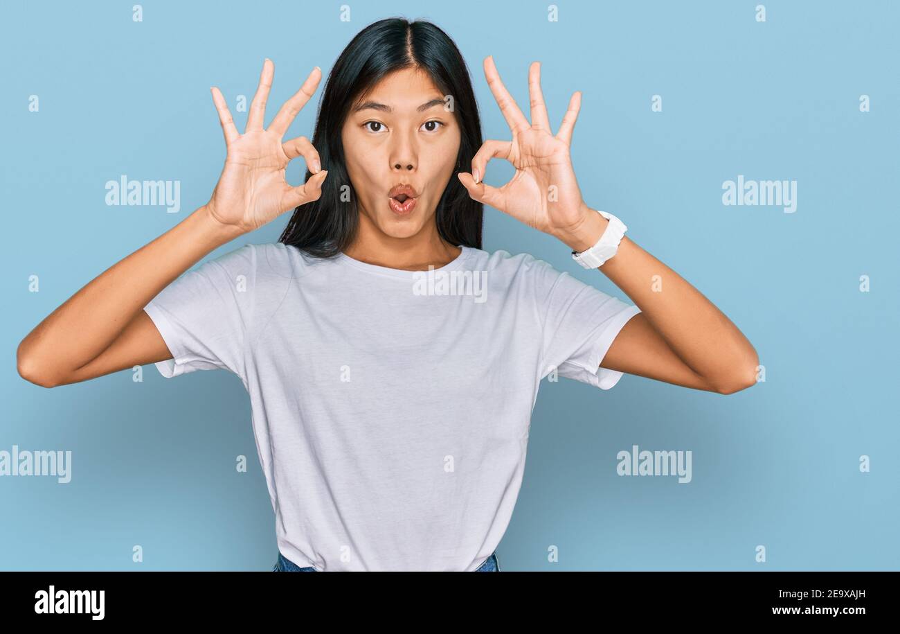 Beautiful young asian woman wearing casual white t shirt looking ...