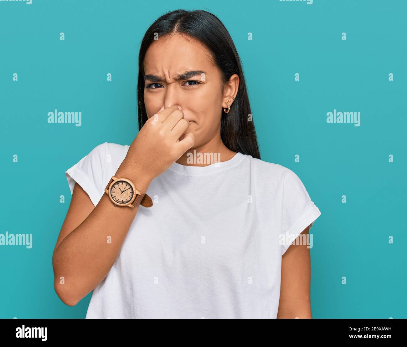 Young asian woman wearing casual white t shirt smelling something ...