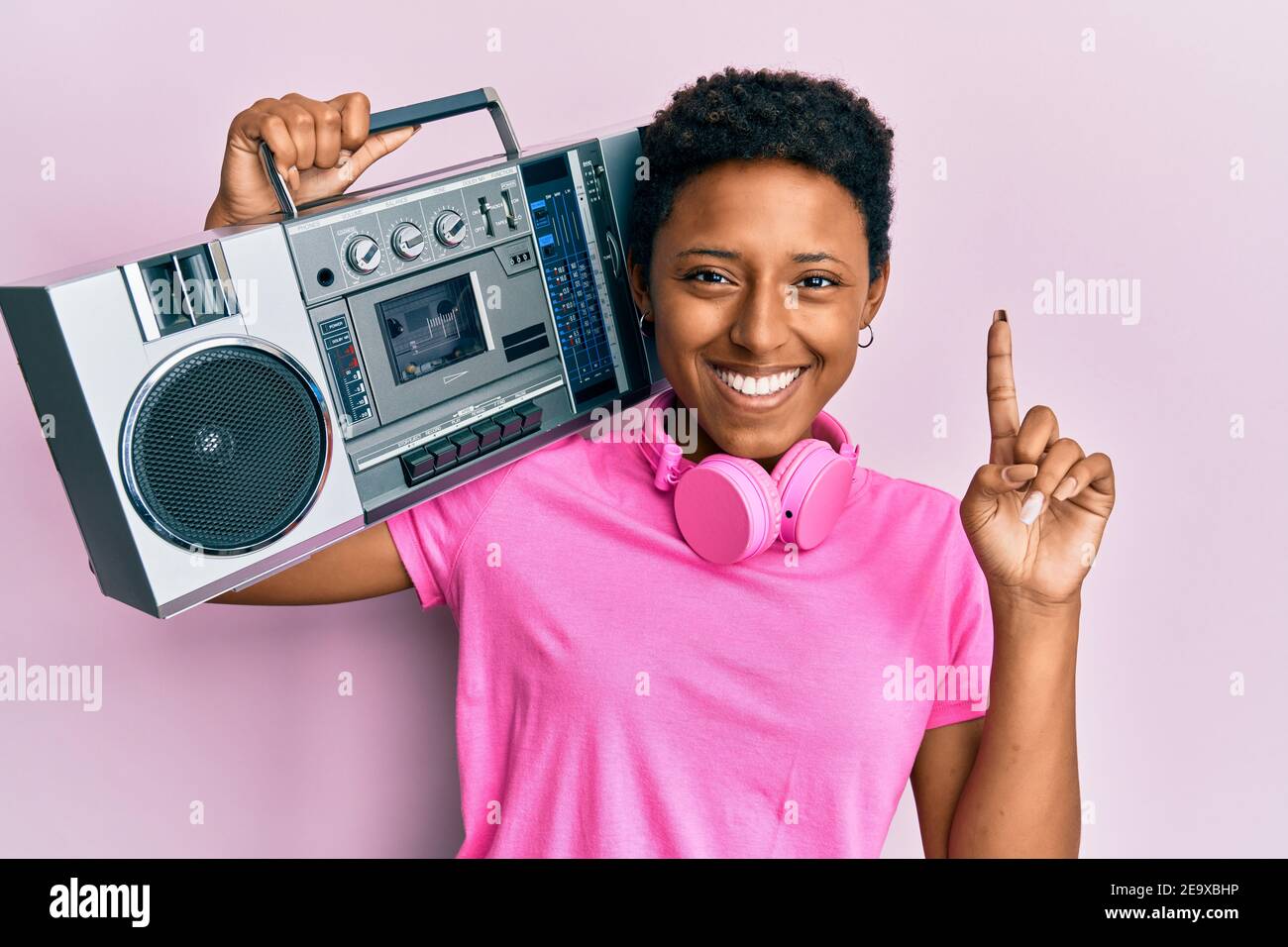 Young african american girl holding boombox, listening to music smiling ...
