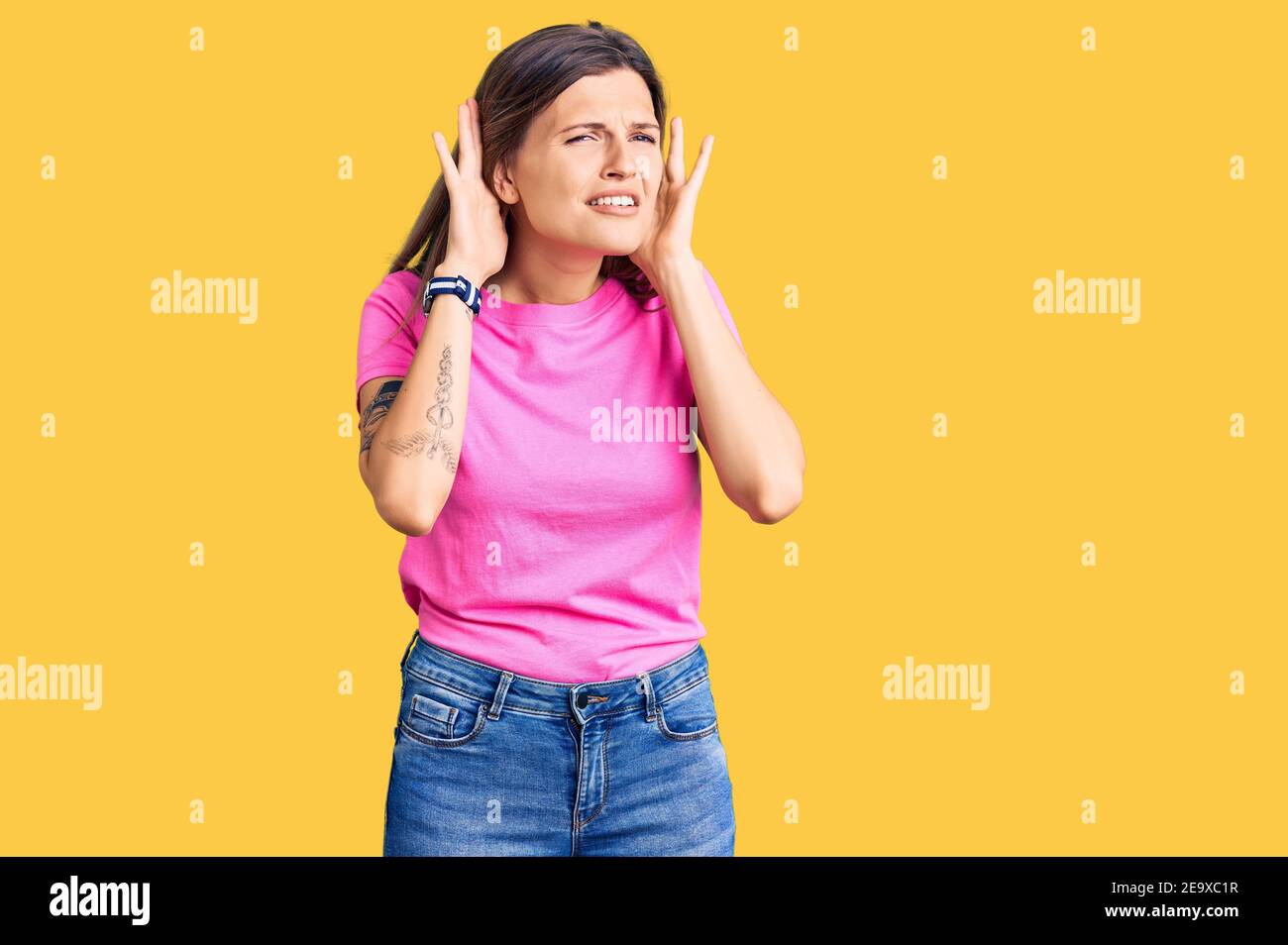 Beautiful caucasian woman wearing casual clothes trying to hear both ...
