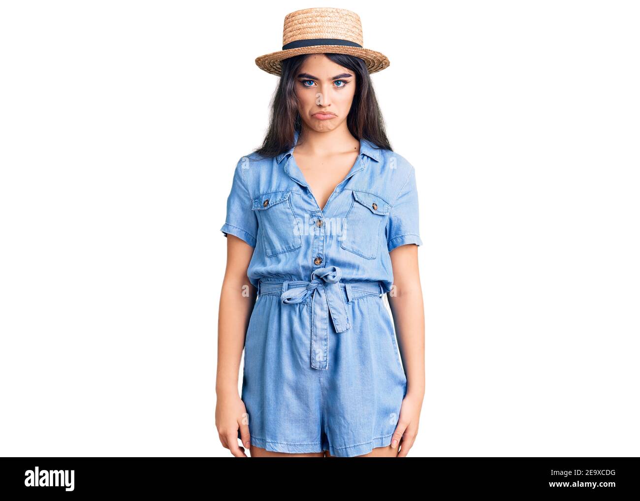 Brunette teenager girl wearing summer hat skeptic and nervous, frowning ...