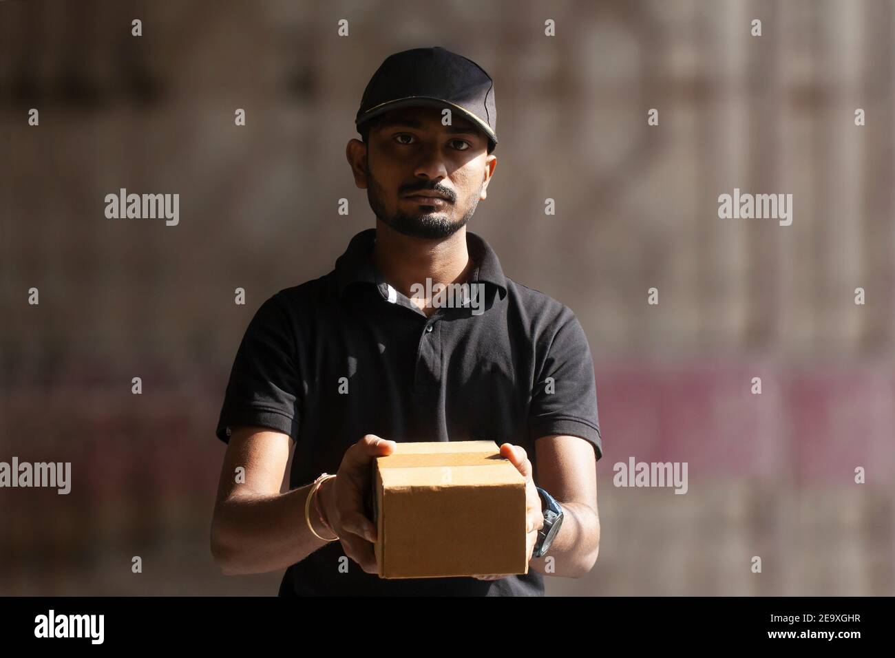 Portrait of confident delivery man giving package to Customers Stock ...