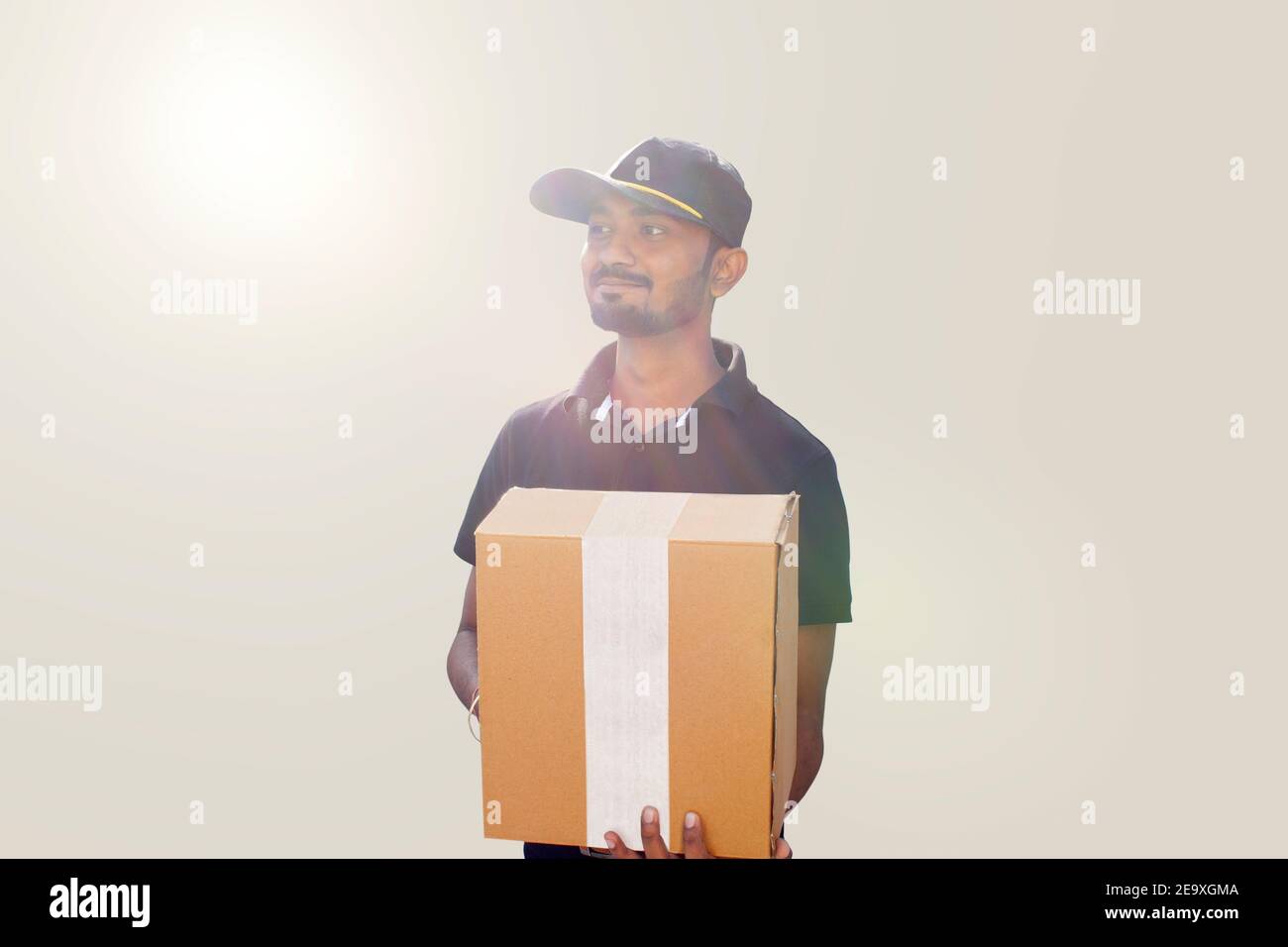 Portrait Of Young Indian Delivery Man Holding Cardboard Box Stock Photo ...