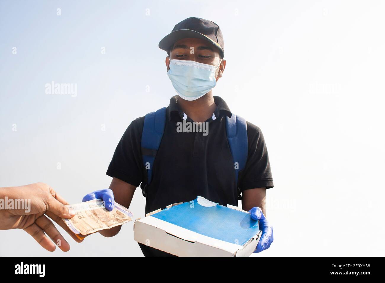 Indian delivery man receiving money from customer against Plain ...