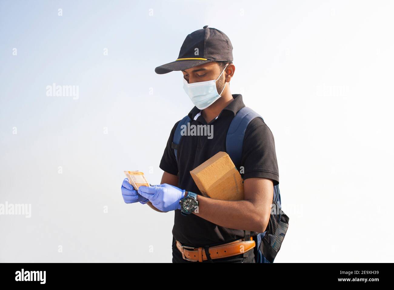 Indian delivery man receiving money from customer against Plain ...