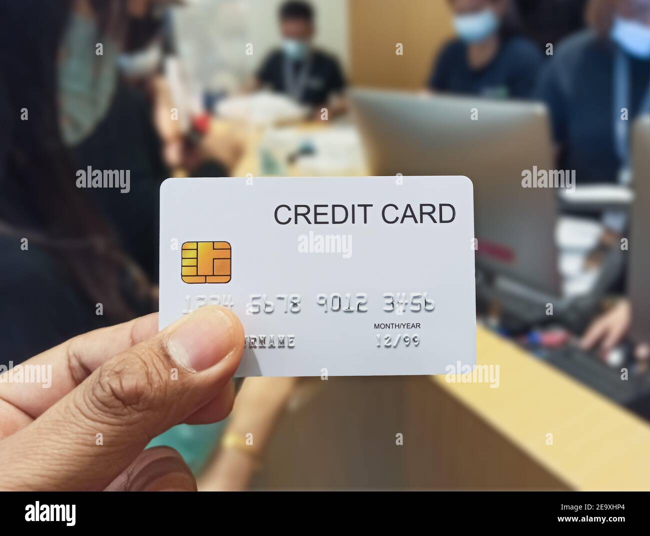Hand holding credit card in department store over the shop store ...