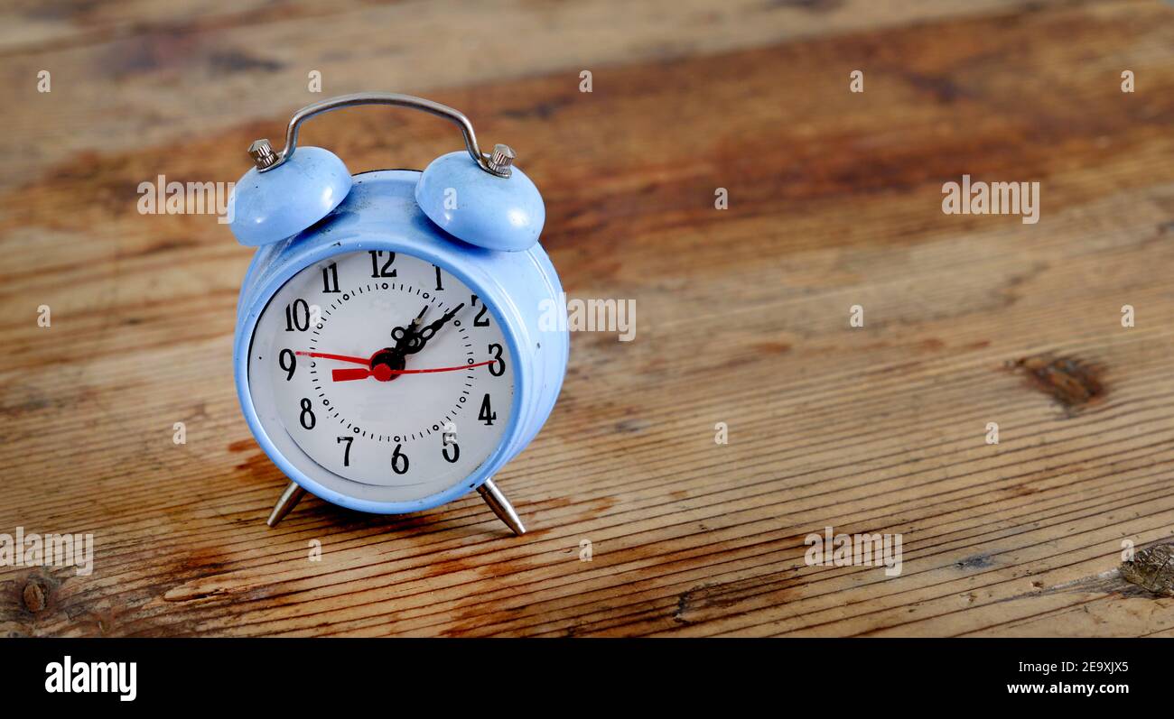 vintage blue alarm clock on old wood background Stock Photo - Alamy