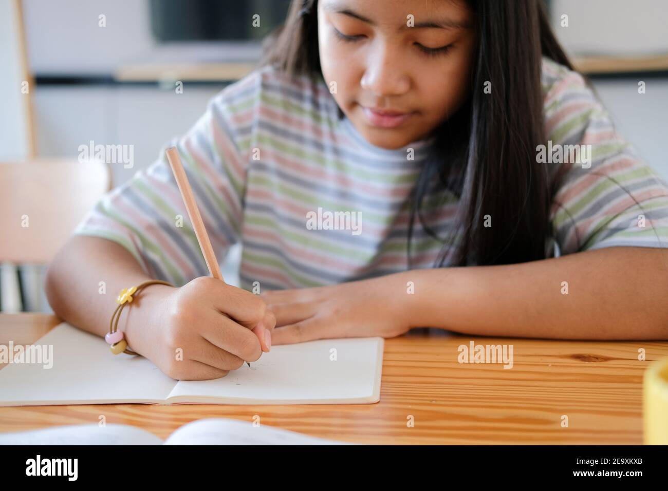 Girl doing homework in library hi-res stock photography and images - Alamy