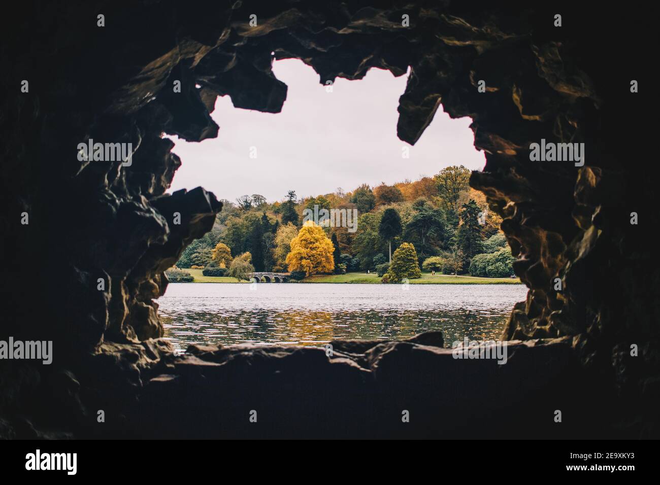 Arched wall opening in Stourhead park, Stourton, England with a view of ...