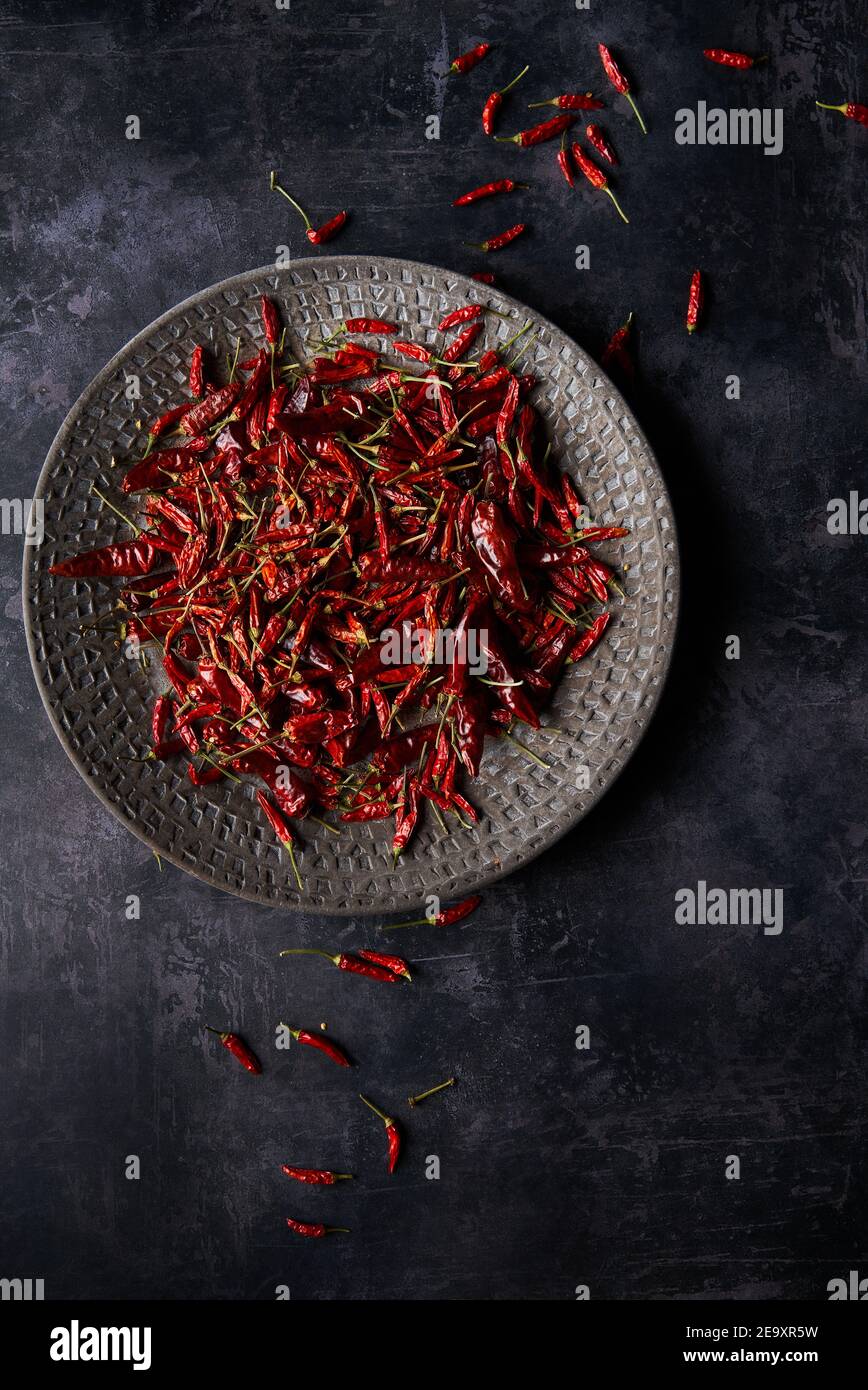 Top view of pile of dried red hot chili peppers placed on plate and ...