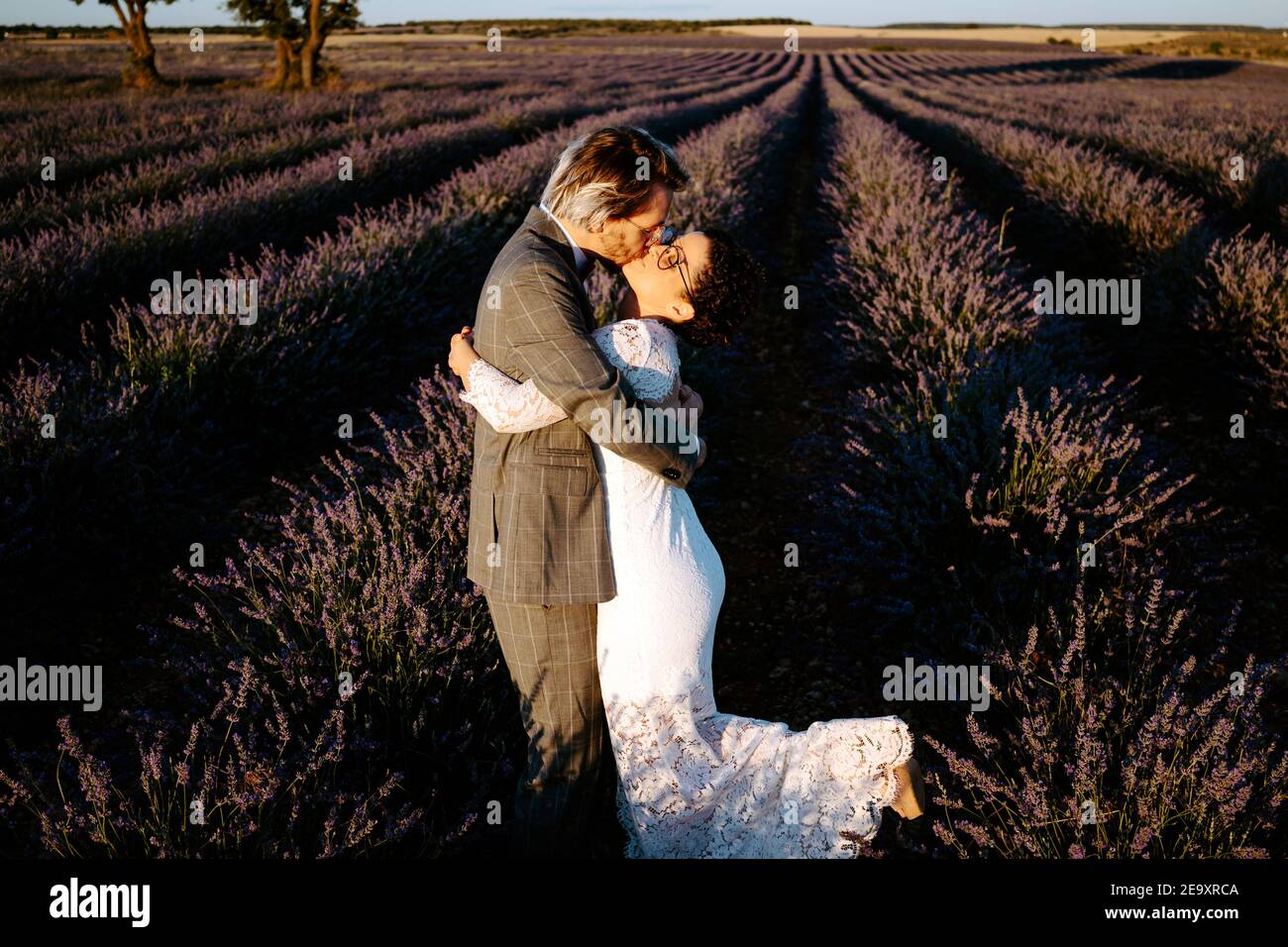 High angle side view of romantic newlywed couple standing face to face ...