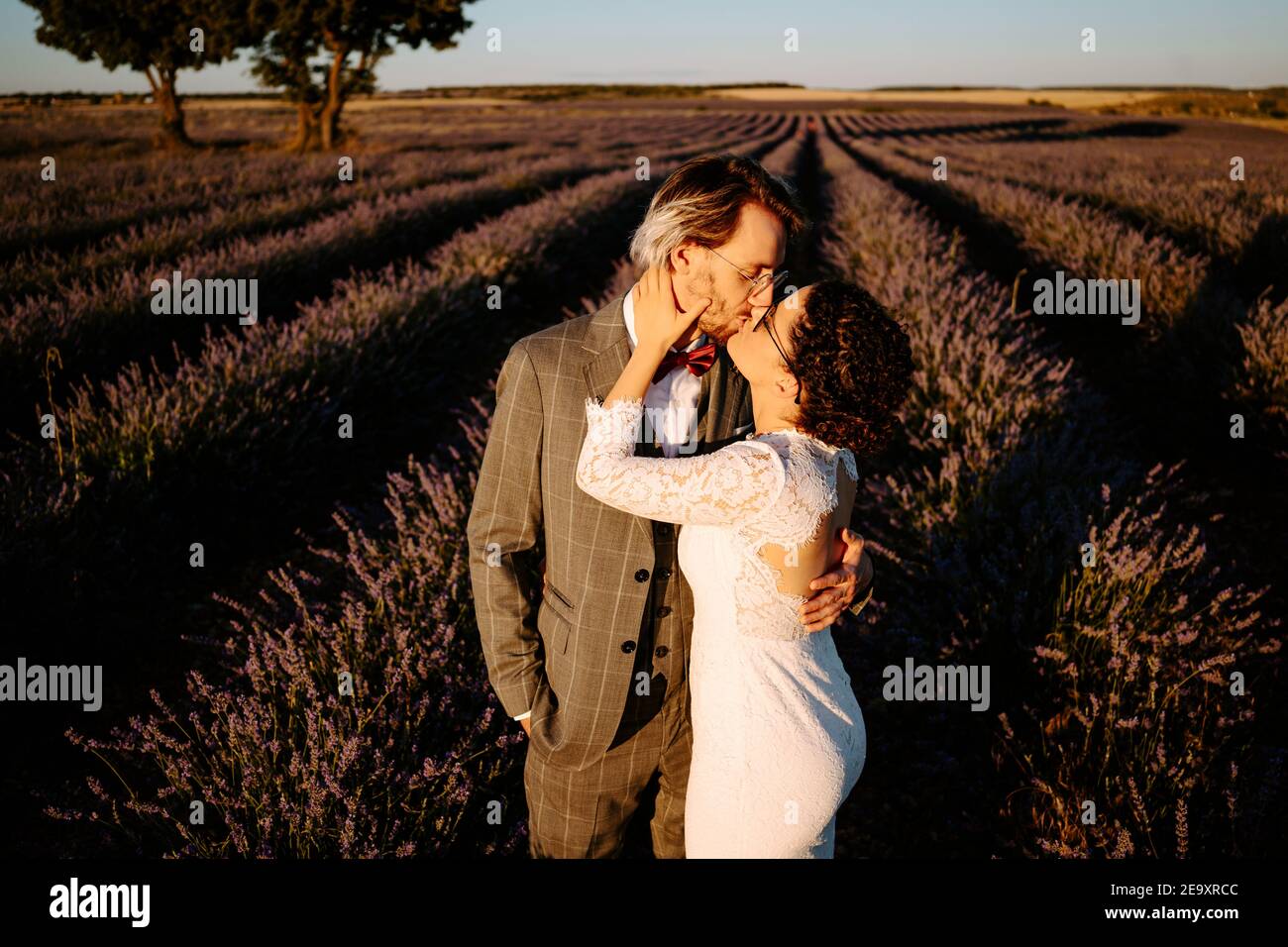 High angle side view of romantic newlywed couple standing face to face ...