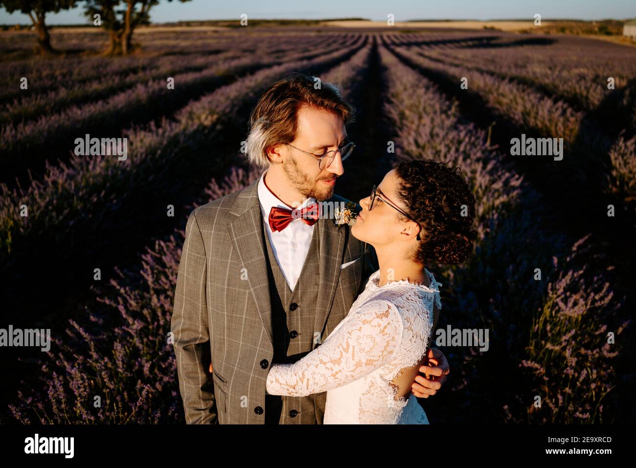 High angle side view of romantic newlywed couple standing face to face ...