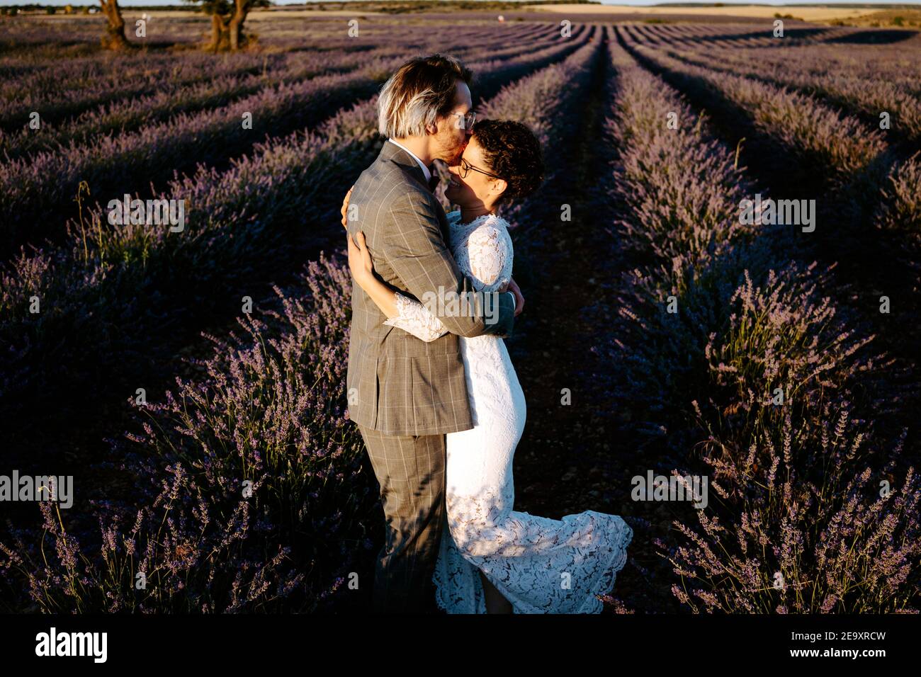 High angle side view of romantic newlywed couple standing face to face ...