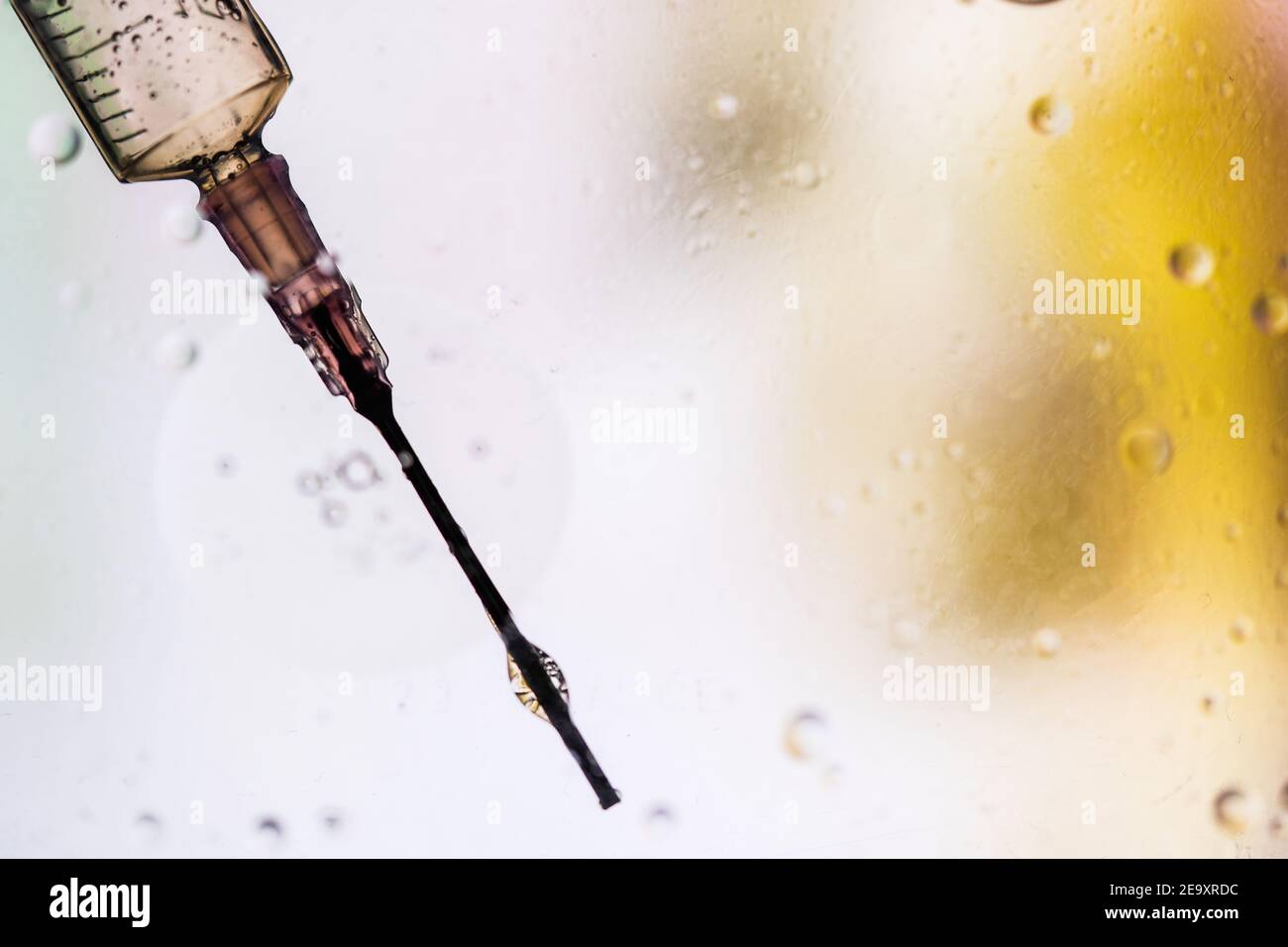 Closeup of needle of syringe filled with vaccine from virus injected in ...