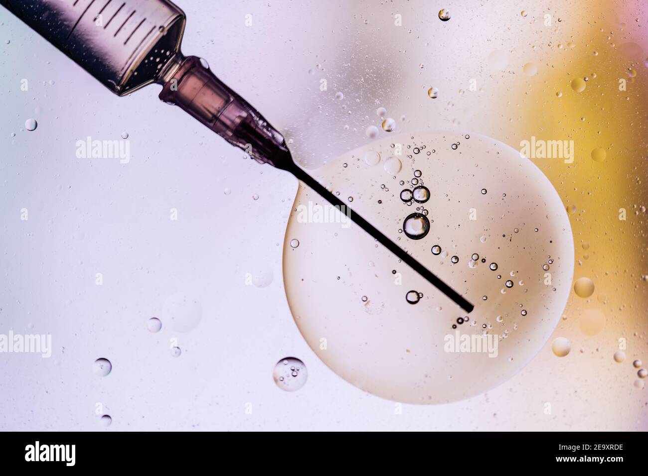 Closeup of needle of syringe filled with vaccine from virus injected in ...