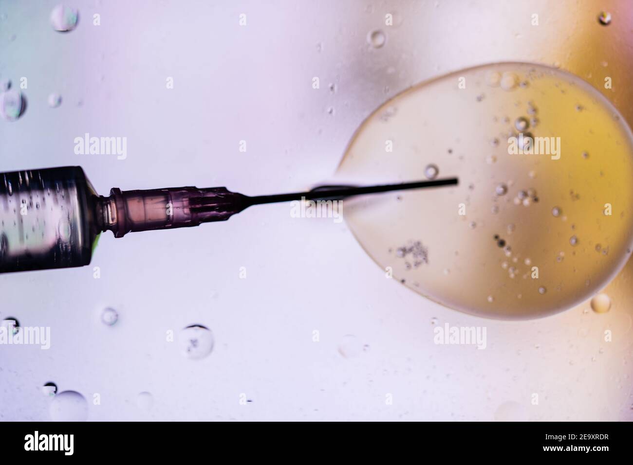 Closeup of needle of syringe filled with vaccine from virus injected in ...