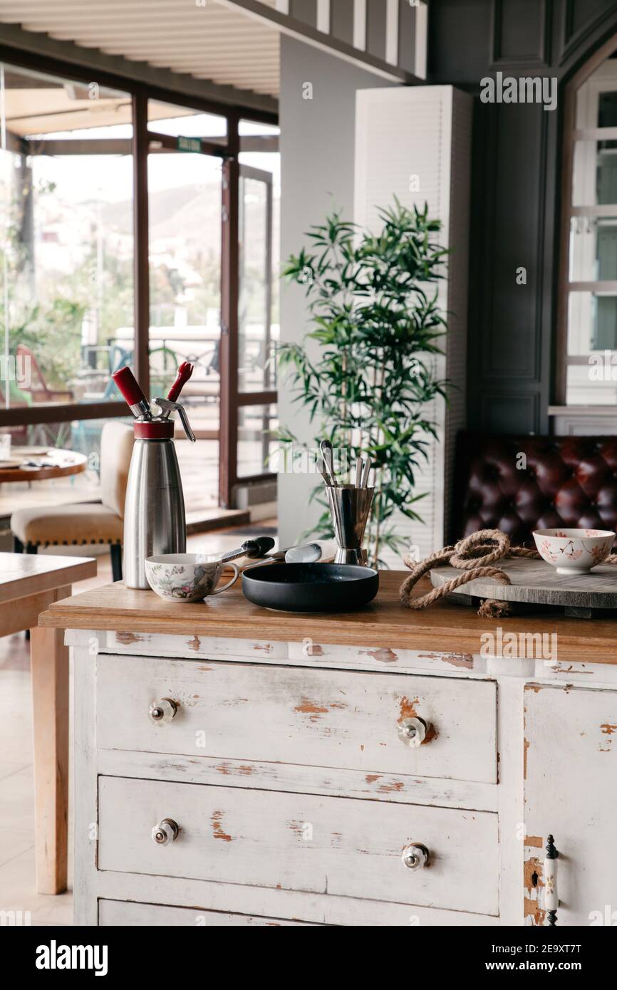 Wooden counter with various kitchenware placed in stylish restaurant ...
