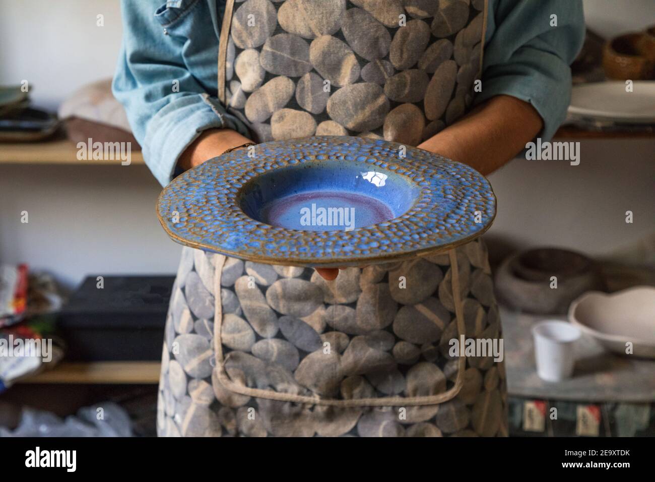 Crop unrecognizable artisan in apron demonstrating creative ceramic ...
