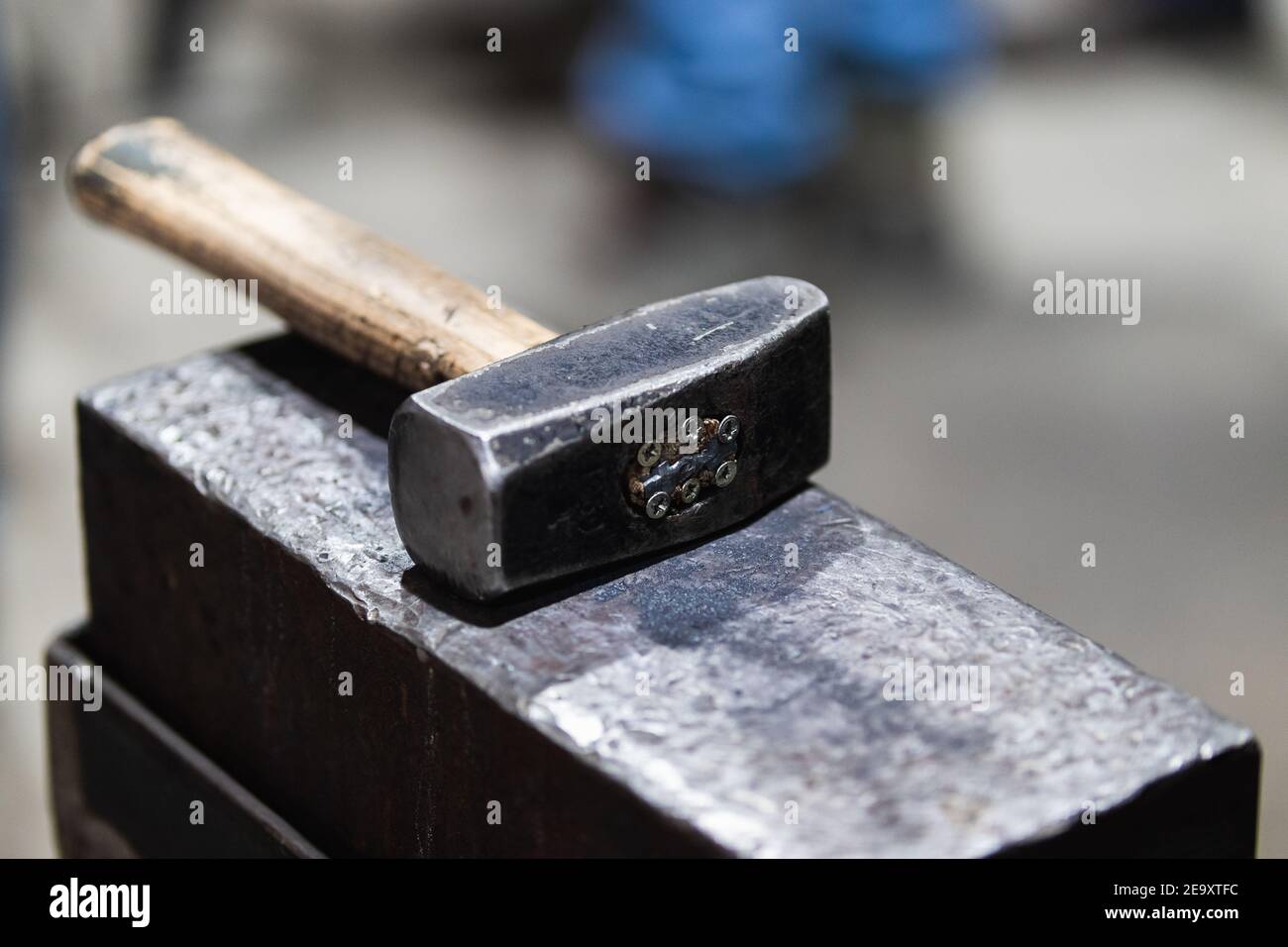 Tool with heavy metal head with wooden handle on workbench in forge ...