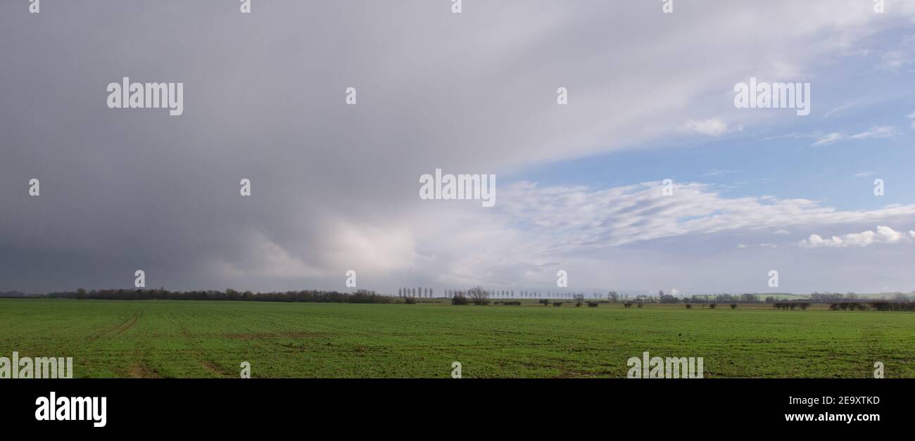 English countryside scene with grey clouds and blue sky with copy space ...