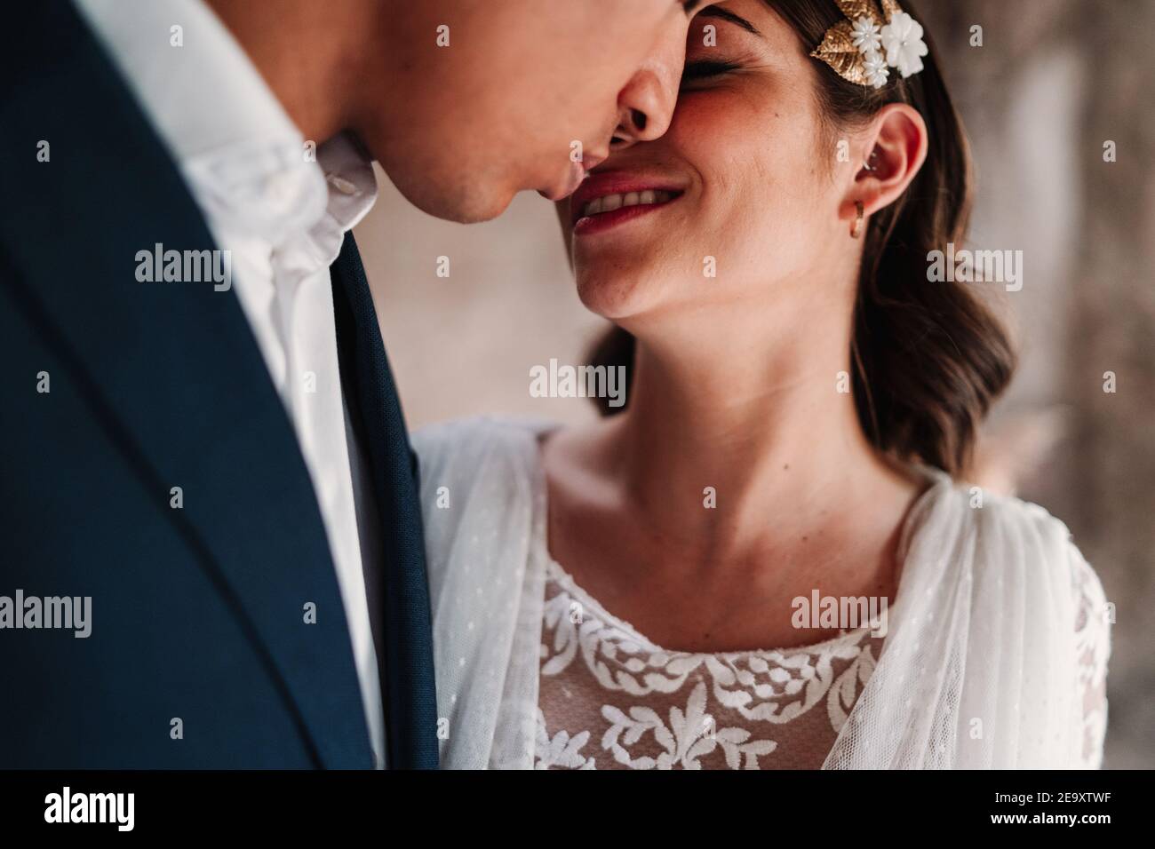 Side view of cropped unrecognizable romantic ethnic newlywed couple in elegant clothes bonding ...