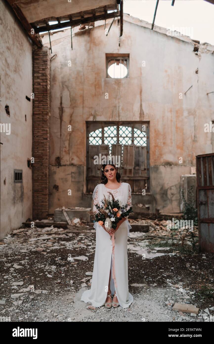 Full body serene young ethnic bride wearing elegant white dress with ...