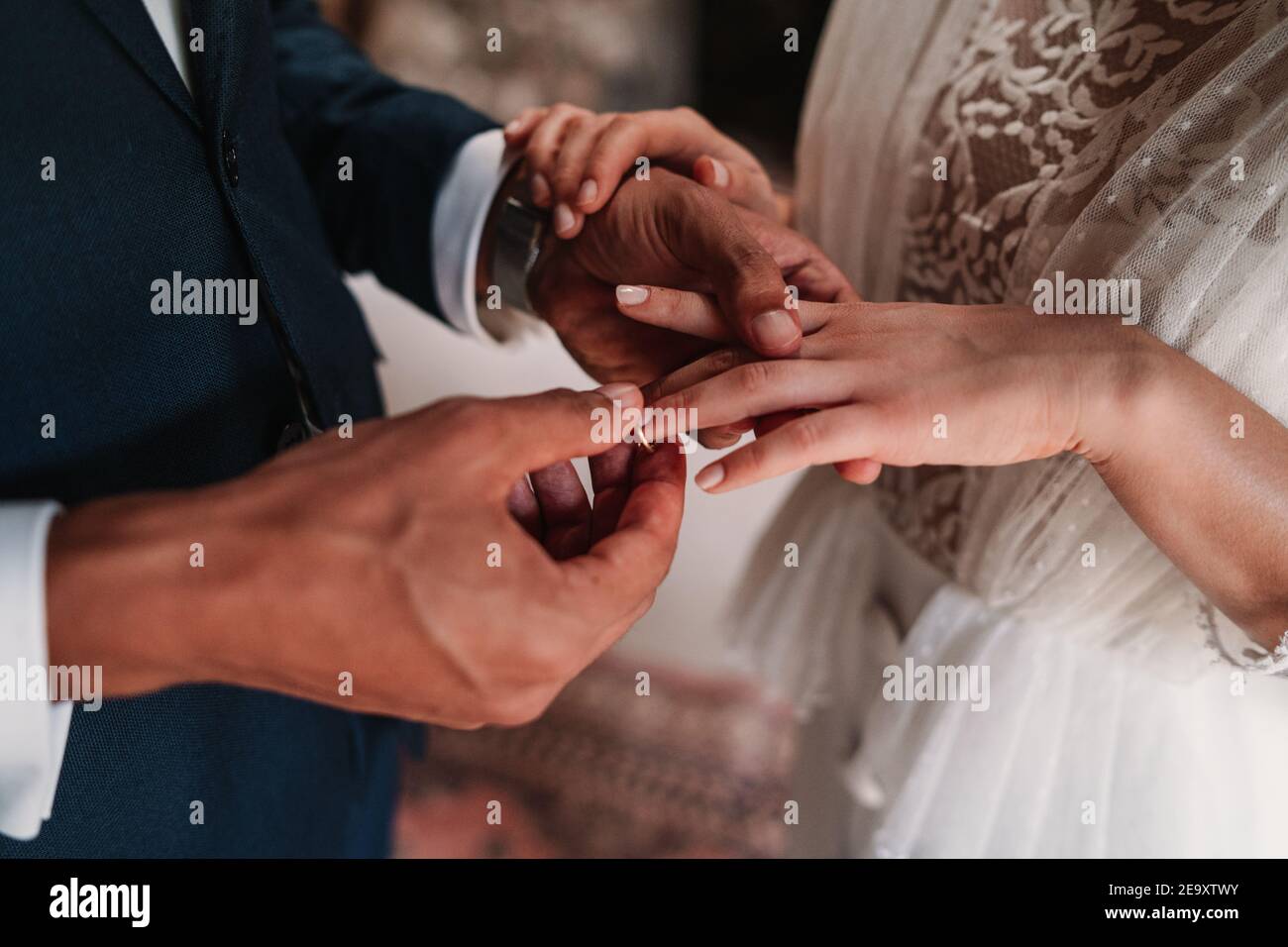 High angle side view of cropped unrecognizable ethnic groom putting ...
