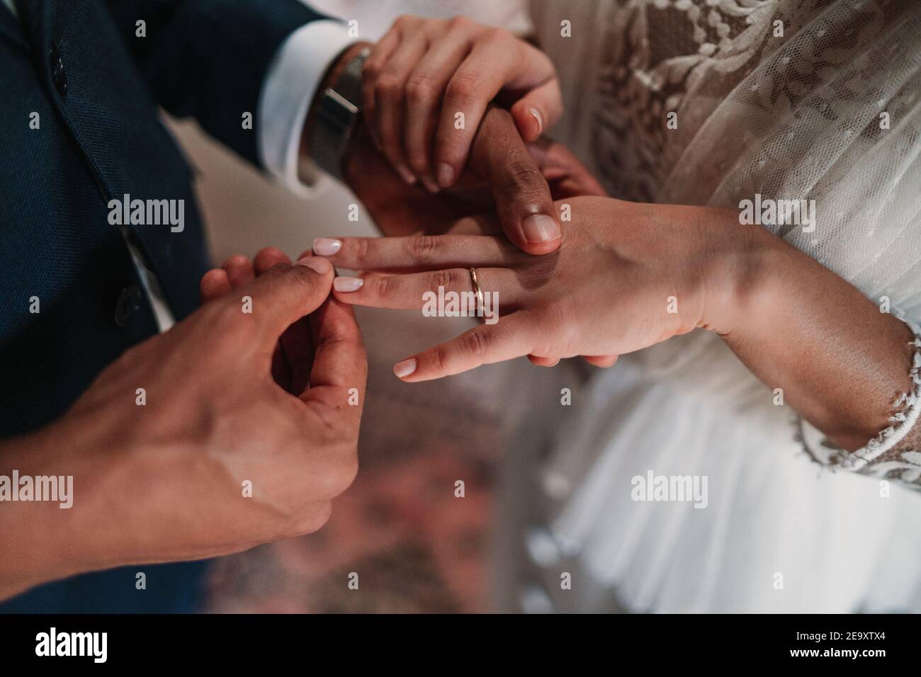High angle side view of cropped unrecognizable ethnic groom putting ...