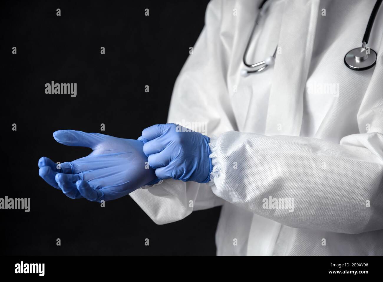 Doctor in medical PPE suit with stethoscope, hands close-up. Doctor ...