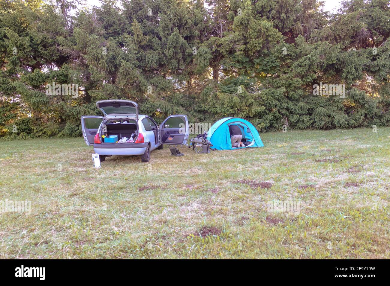 Installation of the tent in a campsite with the car open on a beautiful ...