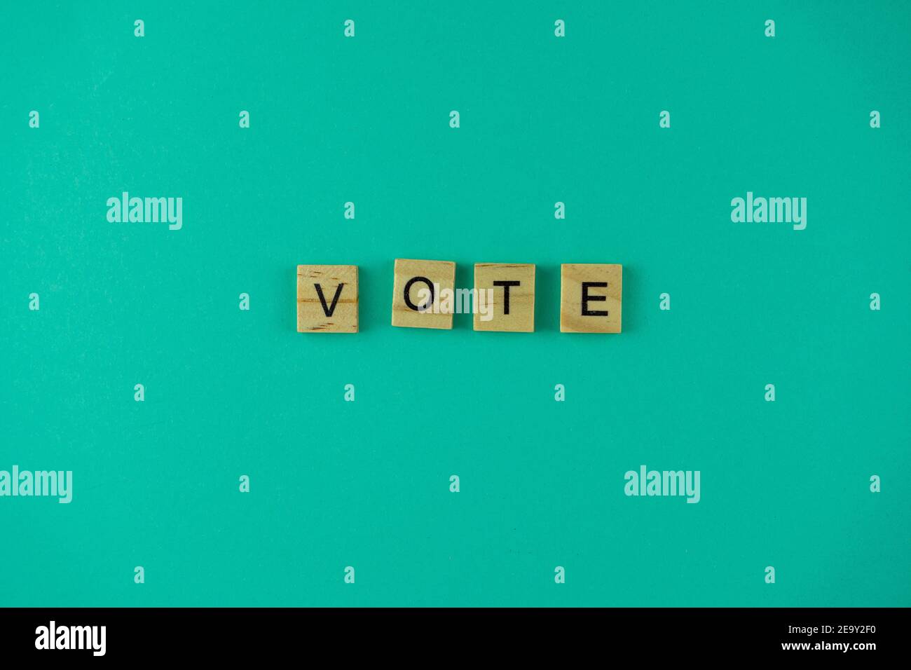 Word VOTE. The phrase is laid out in wooden letters. Top view. Blue ...