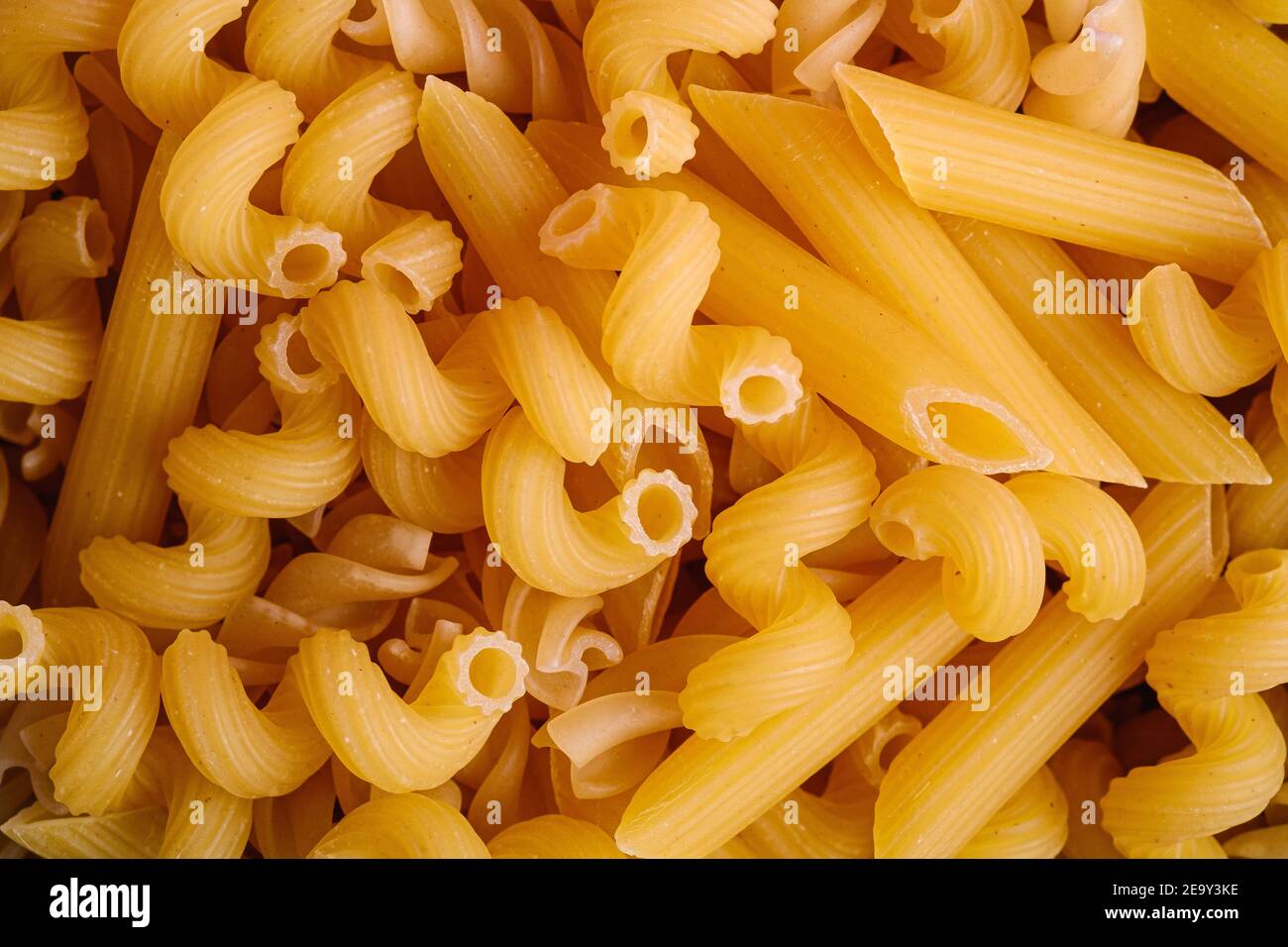 Texture of variety uncooked golden wheat pasta background, top view ...