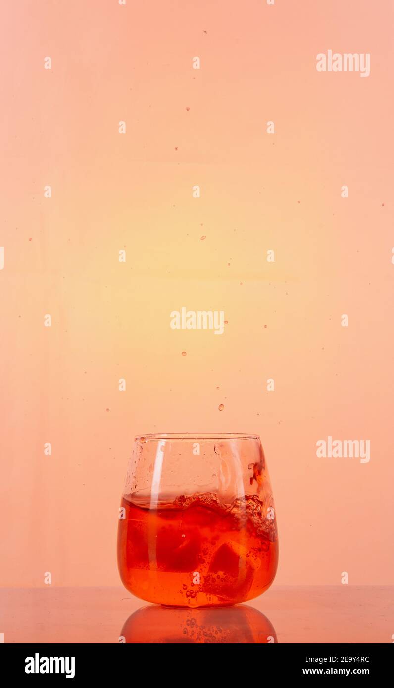 Vertical shot of a refreshing cocktail with drops on delicate peach ...
