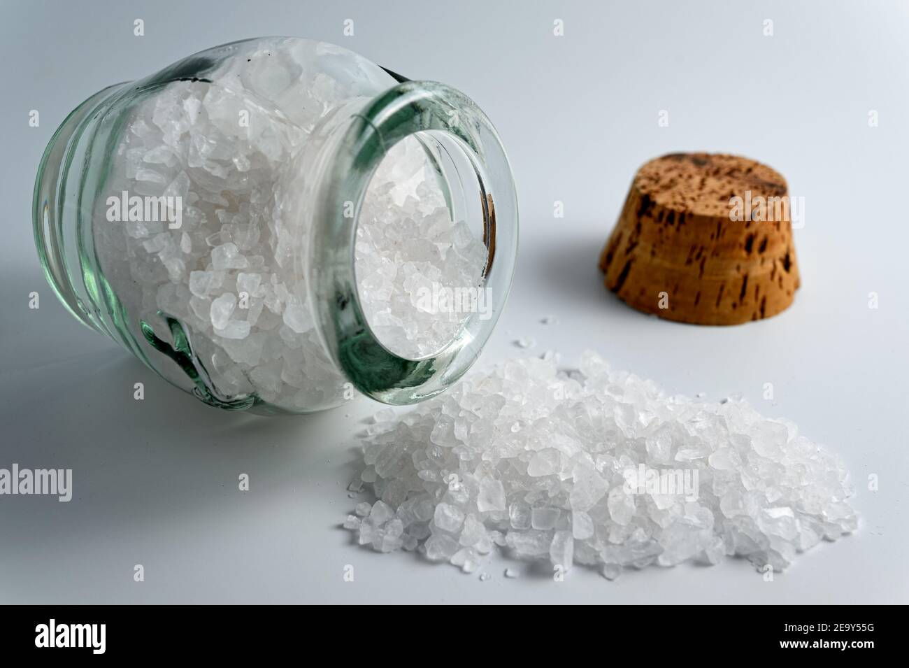 Sea salt in small glass jar on white background Stock Photo - Alamy