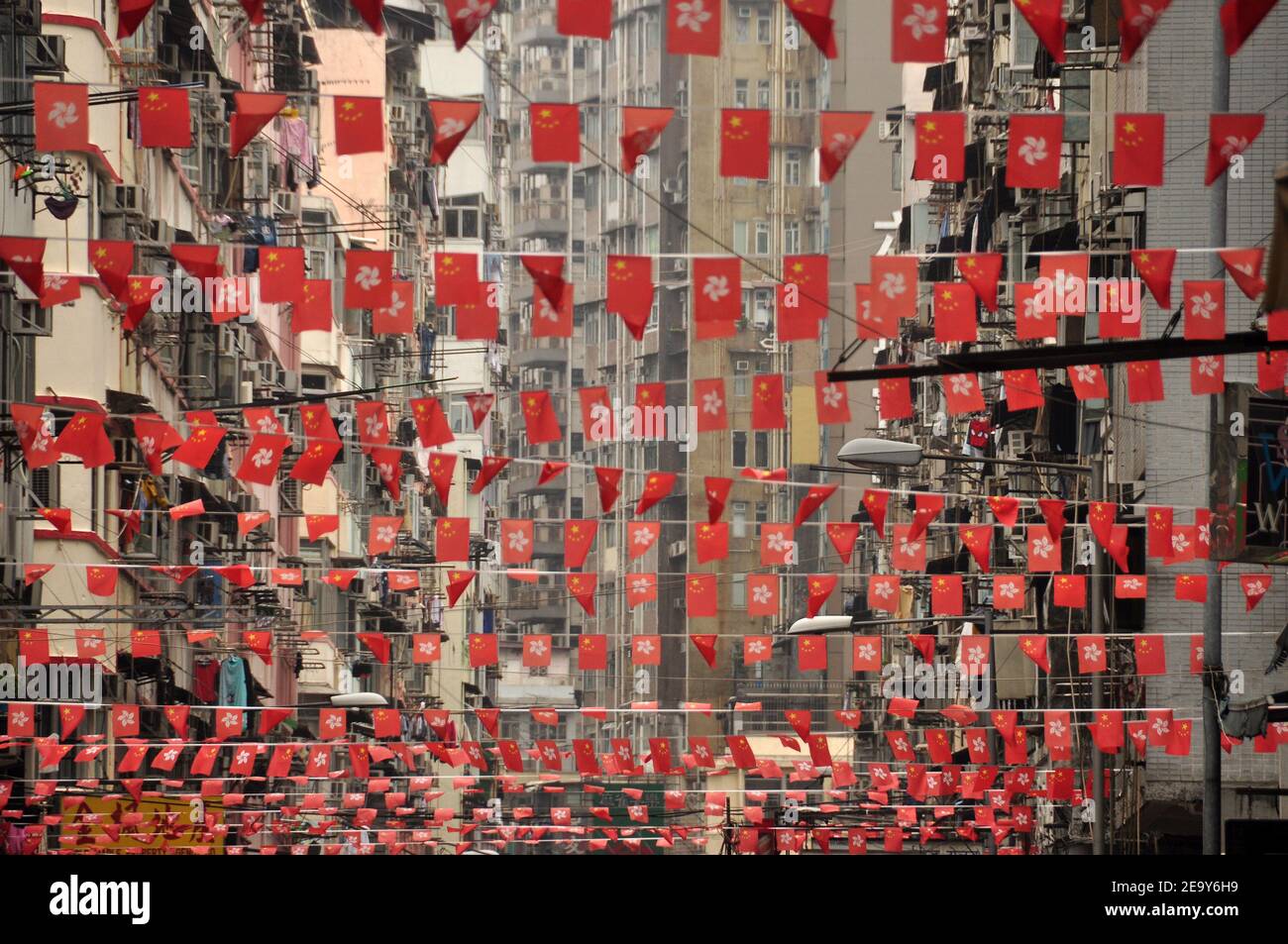 View of rows of strings with waving red flags on street of Singapore ...
